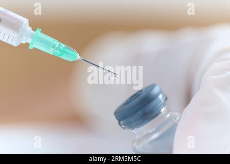 Doctor sucking an injection drug from a vial bottle Stock Photo - Alamy
