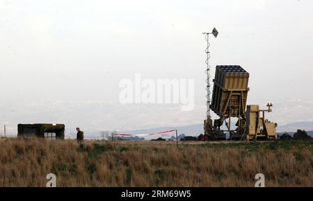 An Israeli soldier stands next to a battery of Israel's Iron Dome ...