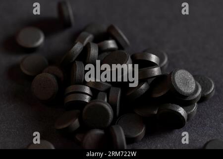 Open and unpacked tablets of black color close-up, a large number of ...