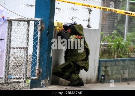Philippine National Police Bomb Squad look at the scene from a distance ...