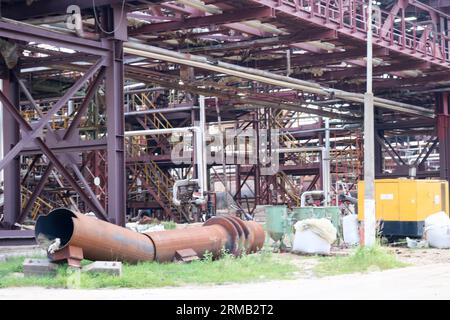 A large iron metal piping trestle with pipes and electric wires and ...