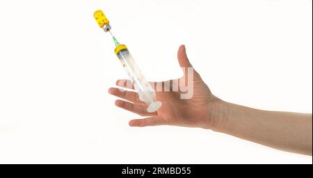 Syringe Falling into Hand against White Background Stock Photo - Alamy