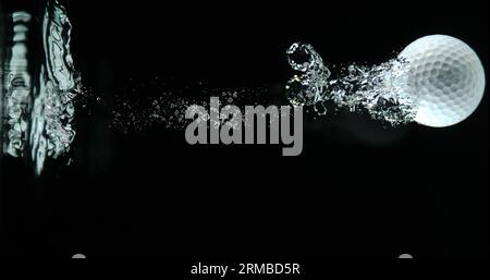 Golf's Ball Falling into Water against Black background Stock Photo - Alamy