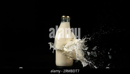 Bottle of Milk Exploding against Black Background Stock Photo - Alamy