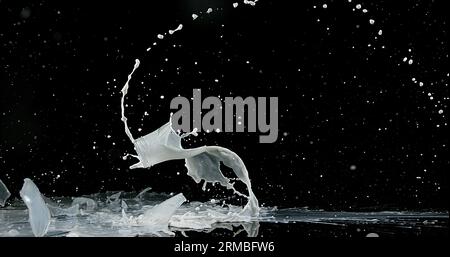 Bottle of Milk Falling and Exploging against Black Background Stock ...