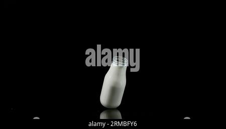 Bottle of Milk Falling and Exploging against Black Background Stock ...