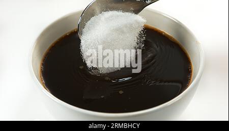 Sugar Falling into Bowl of Coffee against White Background Stock Photo ...