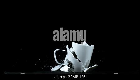 Cup falling and exploding on Black Background Stock Photo - Alamy