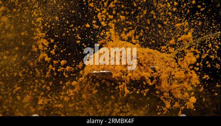 Spoon and Curry Powder falling from Spoon against Black Background ...