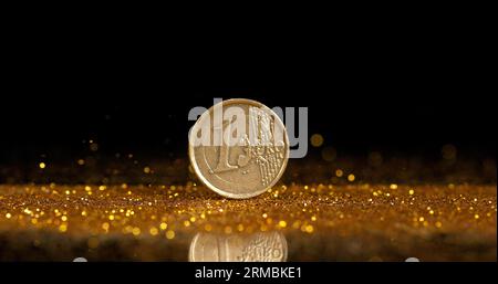 Coin of 1 Euro Rolling on Gold Powder against Black Background Stock ...
