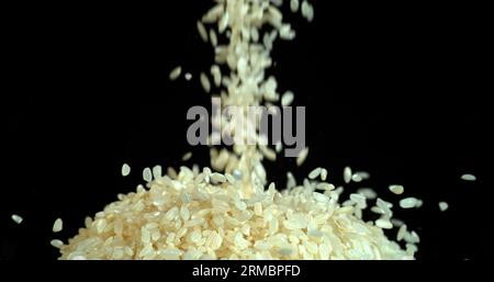 Rice falling against Black Background Stock Photo - Alamy