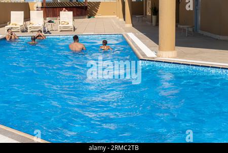 People swim in an outdoor swimming pool in London, Tuesday, June 23 ...