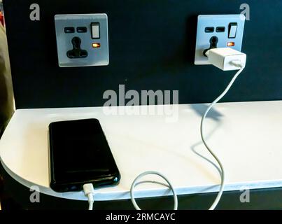 Mobile phones charging station with electric outlet. Cell phone ...