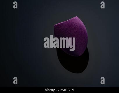 Makeup sponge on dark background Stock Photo - Alamy