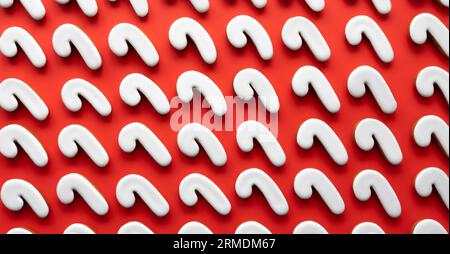 A lot of gingerbread candy cane shaped cookies on a red background ...