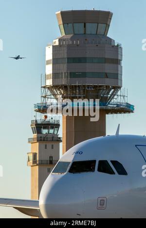 Passenger plane taking off past the large windows of an airport ...