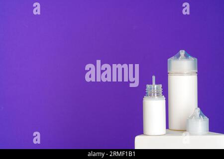 Vape liquid dripping with cap on purple background Stock Photo - Alamy