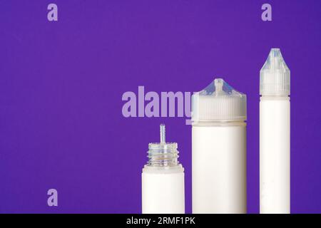 Vape liquid dripping with cap on purple background Stock Photo - Alamy