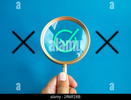 Magnifier enlarging the correct choice or check mark on yellow ...