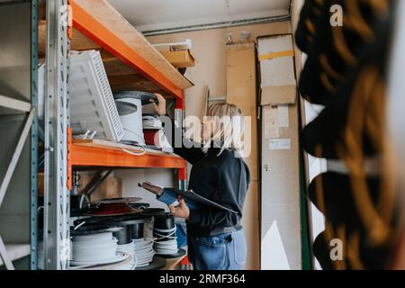 Female worker checking equipment inventory Stock Photo - Alamy
