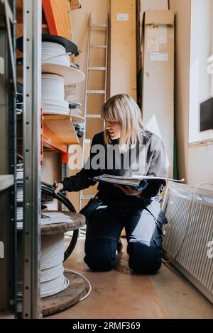 Female worker checking equipment inventory Stock Photo - Alamy