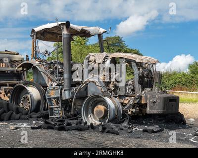 Burnt out remains of farm tractor in a field following a fire which ...