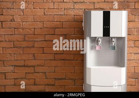 Modern water cooler on brick background Stock Photo - Alamy