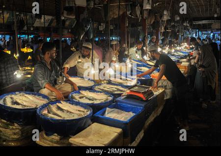 People buy Hilsa fish at the Lalbazar fish market in Sylhet city ...