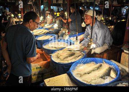 People buy Hilsa fish at the Lalbazar fish market in Sylhet city ...