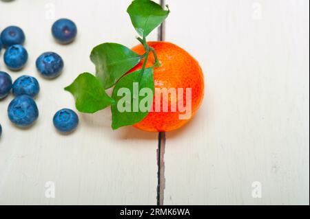 Tangerine and blueberry on white rustic wood table Stock Photo - Alamy