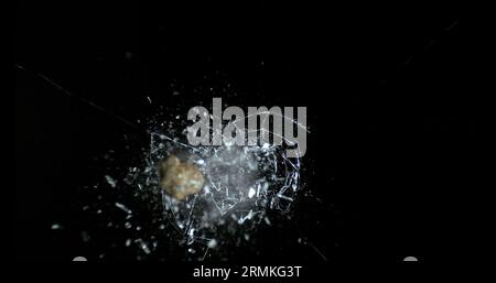 Stone breaking Pane of Glass against Black Background Stock Photo - Alamy