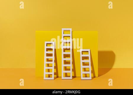Ladders arrangement with yellow background Stock Photo - Alamy