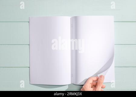 Hand turning white page top view Stock Photo - Alamy