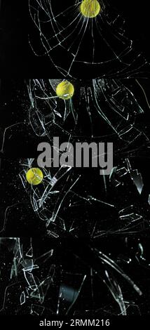 Tennis Ball breaking Pane of Glass against Black Background Stock Photo ...