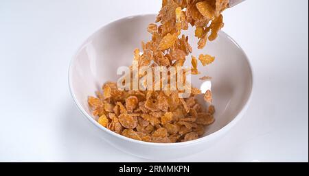 Cereals falling in a white bowl on a wooden table Stock Photo - Alamy