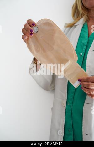 a female doctor showing a ileostomy bag after a colon cancer in a ...