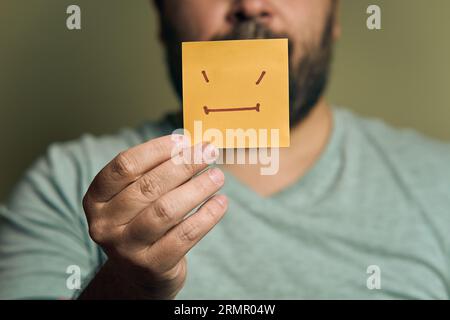 Displeased and disappointed man in orange sweater, grimacing and ...