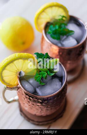 Moscow mule cocktails in copper mug with lime, ice, ginger beer, vodka ...