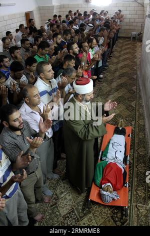 Mourners pray beside the body of 6-year-old Palestinian girl Menna ...