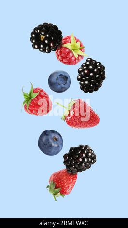 Fresh strawberries of the season, one whole and two half on a wooden ...