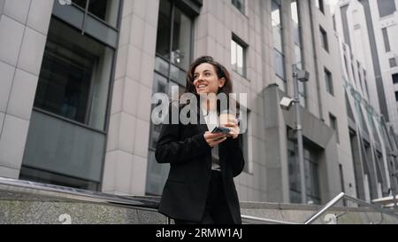 Smiling black girl drinking coffe from reusable cup at cafe. Zero waste ...