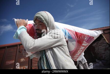 (141112) -- HAIRATAN, Nov. 12, 2014 -- An Afghan labor carries a bag of ...