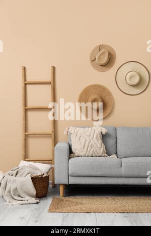 Grey sofa with cushion, plaid and hanging lamp near blue wall Stock ...