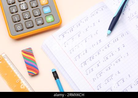 Copybook with maths formulas, calculator and stationery on beige wooden ...