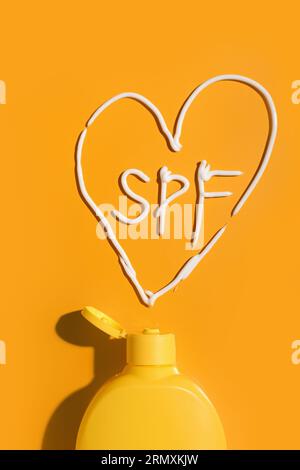 Sunscreen cream, drawing of heart and word SPF on yellow background ...