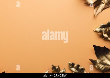 Metallic gold autumn leaves lying on orange background Stock Photo - Alamy