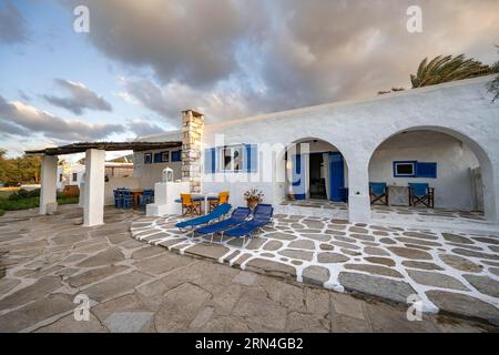 White Cycladic house with terrace with chairs and sun loungers, Holiday ...