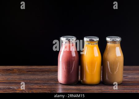 Smoothie bottles wooden surface Stock Photo - Alamy