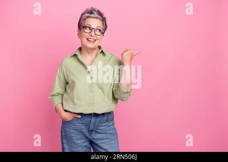 Photo of charming cheerful lady indicate thumb empty space proposition ...