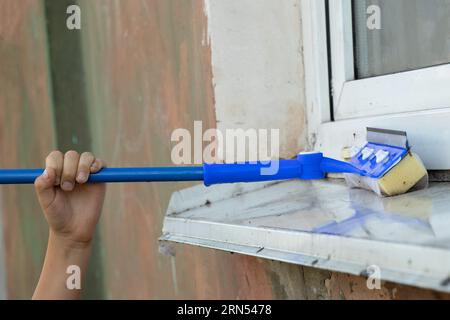 A child washes a dirty window with a mop from the street, wash windows ...